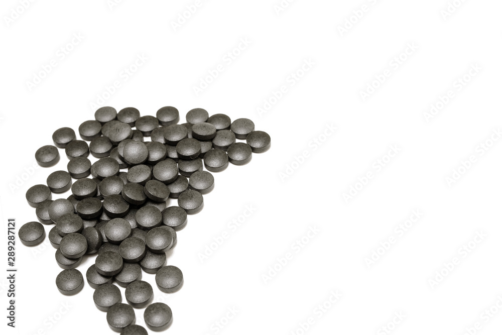 Round black iron pills on white background. Many tablets of Ferrous ...