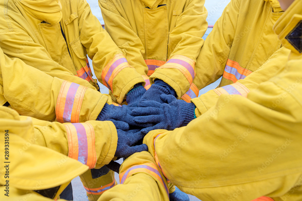 Firefighters team in uniform. Members of the fireman clash their hands ...