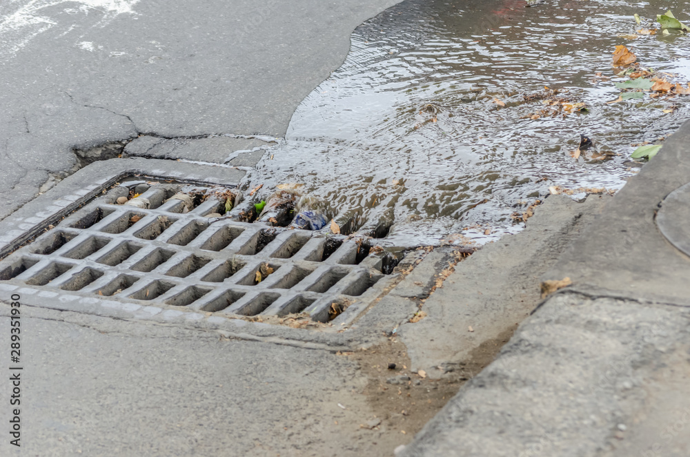 Water drains into a storm drain on the road close-up Stock Photo ...