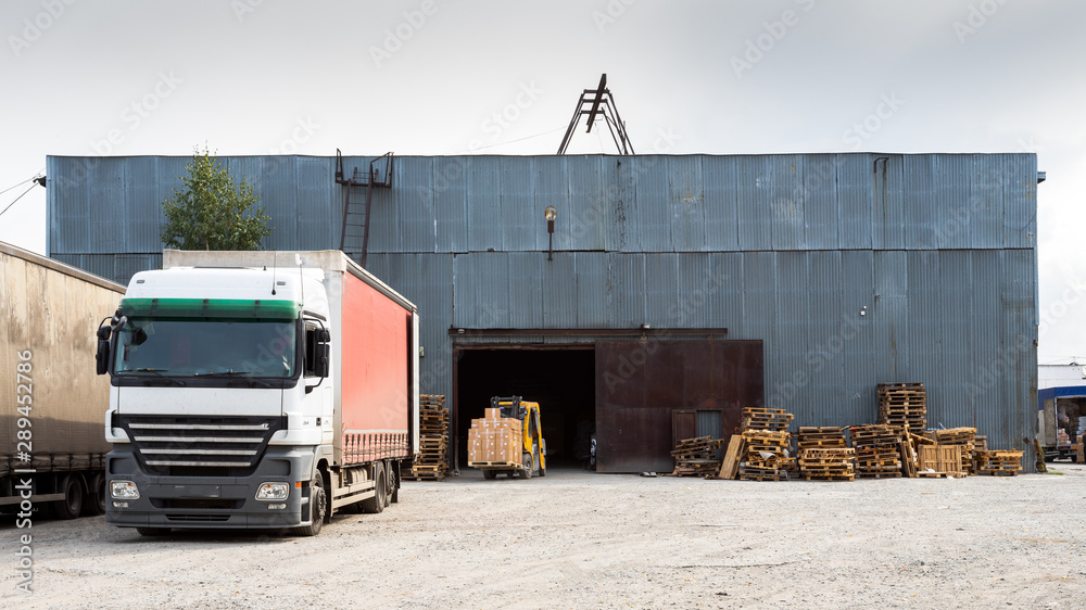 Delivering and supply concept image. Trucks loading at facility in the ...