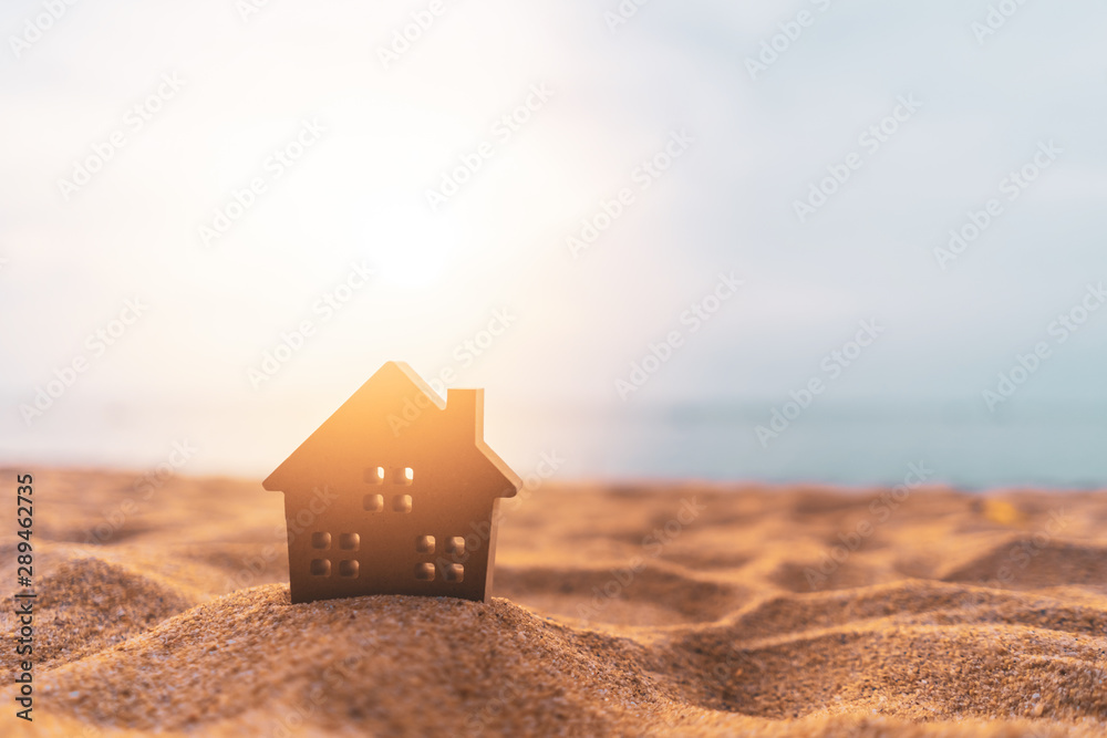 Small home model on sunset beach sand texture background. Stock Photo ...