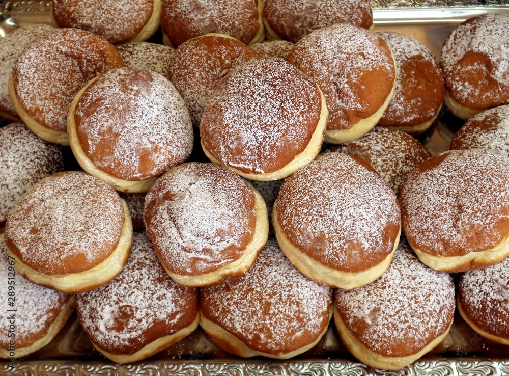 Top view of many Krapfen, also known as Berliner, on a tray of a pastry ...