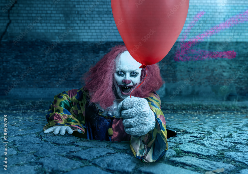 scary clown with a balloon rising from the sewer Stock Photo | Adobe Stock
