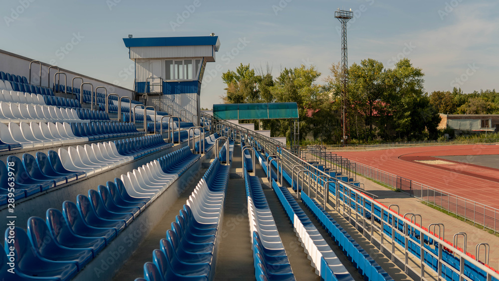 Bleachers in a sports stadium. Red and white seats in a large street ...