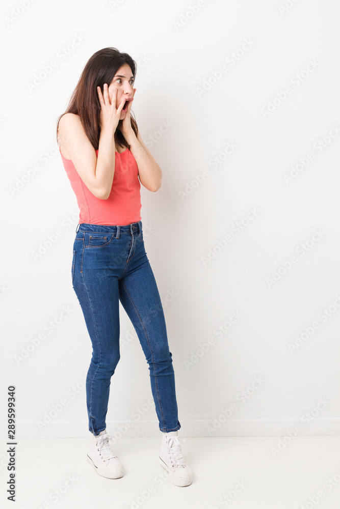 Full body young woman on white background shouts loud, keeps eyes ...