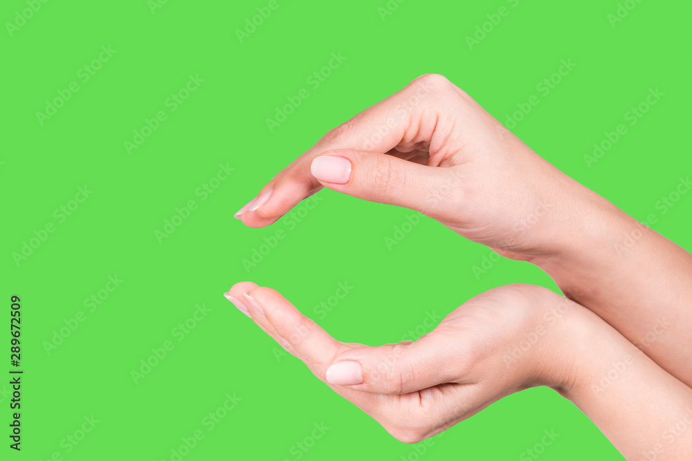 Closeup side view of two beautiful female manicured hands making cupped ...