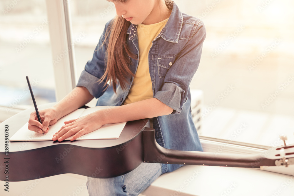 Crop girl making notes on guitar Stock Photo | Adobe Stock