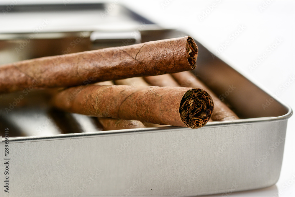 Some tobacco cigarillos in grey metal box. Close-up, high resolution ...