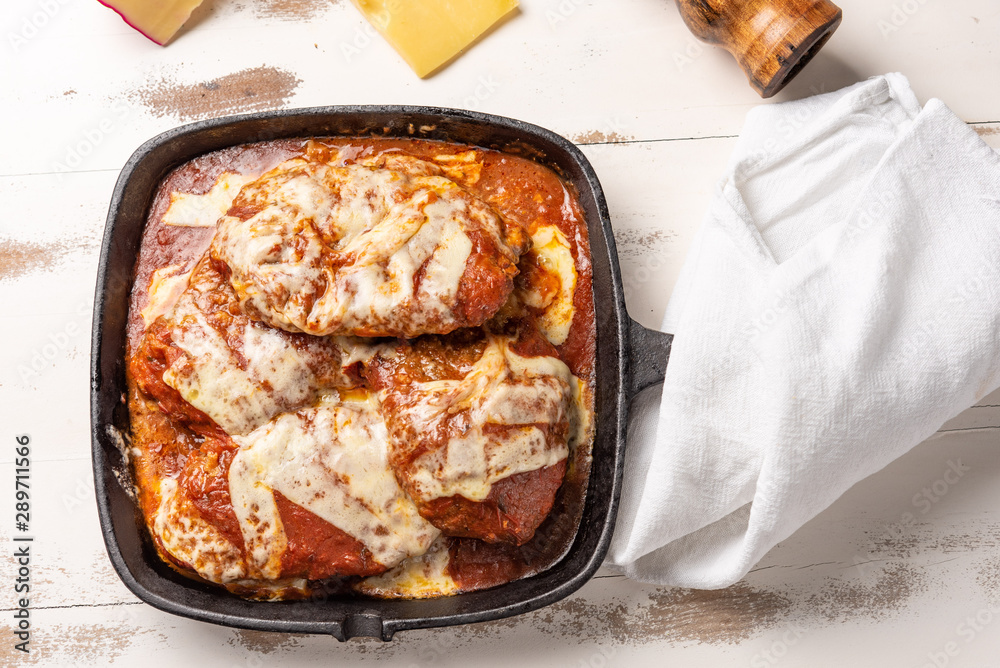 Parmegiana Steak also known as Filet Parmegiana in a black iron pan on ...