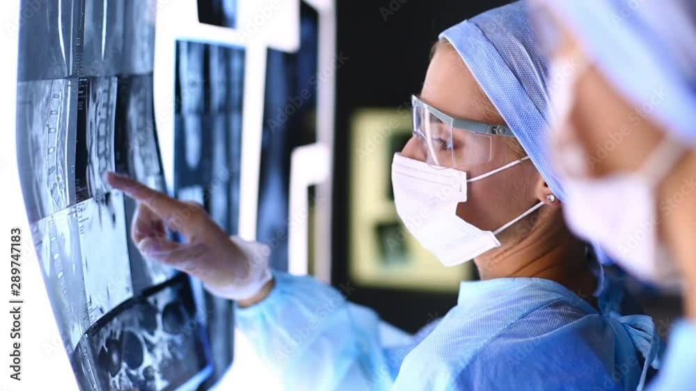 Doctor examines x-ray , holding it in hands indoors. Doctors working ...