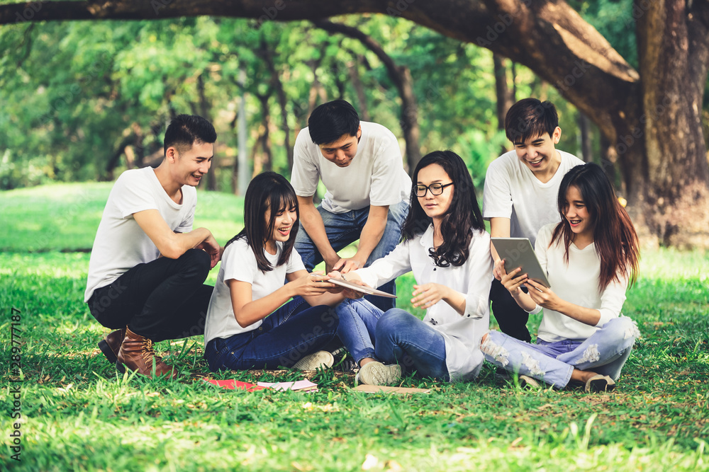 Team of young students studying in a group project in the park of ...