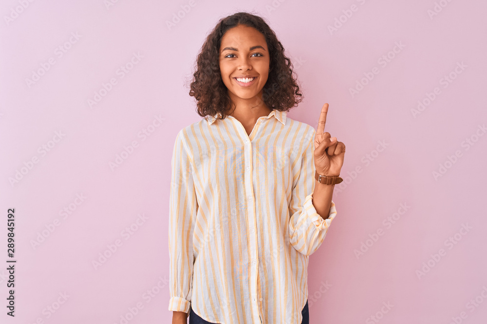 Young Brazilian Woman Wearing Striped Shirt Standing Over Isolated Pink