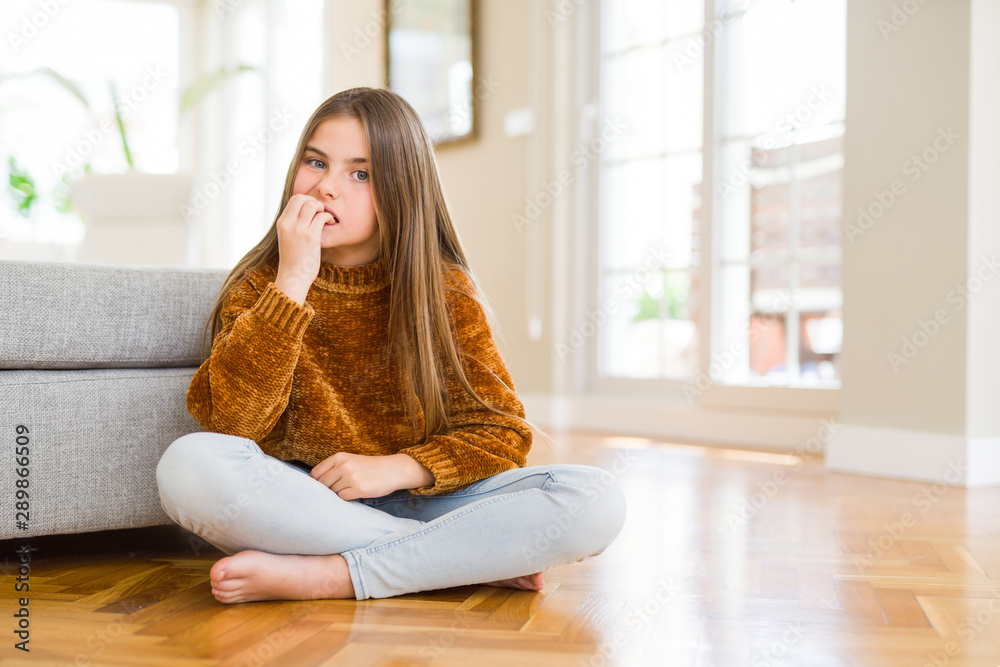 Beautiful young girl kid sitting on the floor at home looking stressed ...