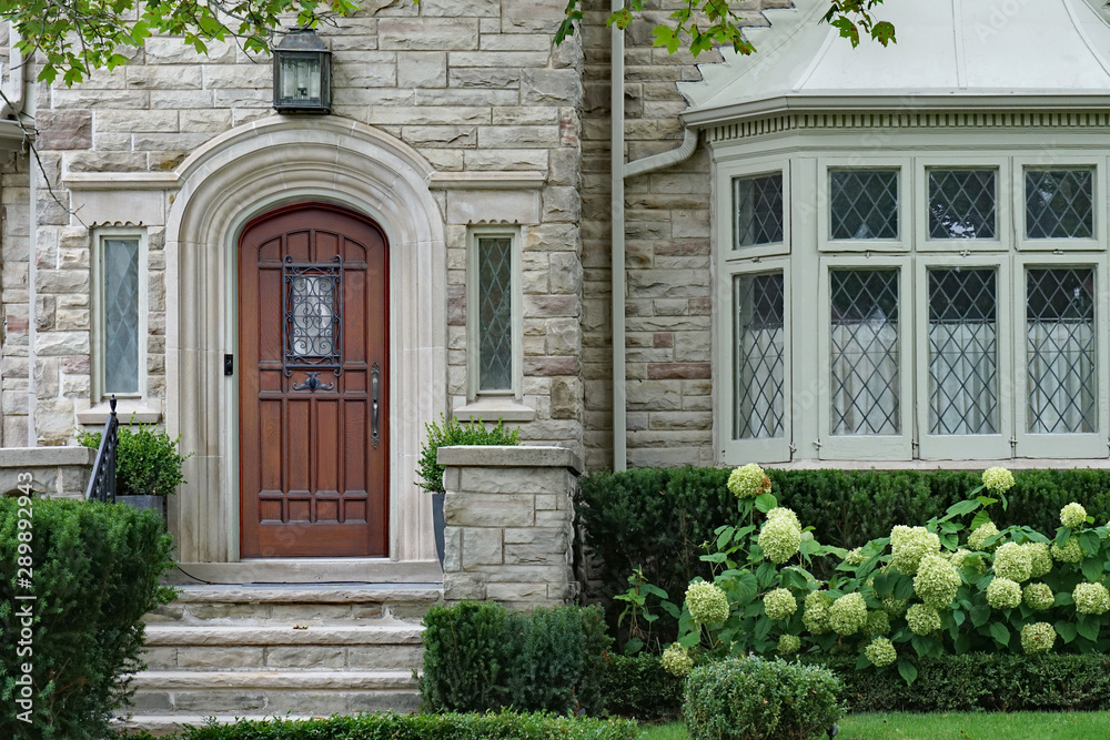 stone faced house with leaded glass windows and elegant wooden front ...