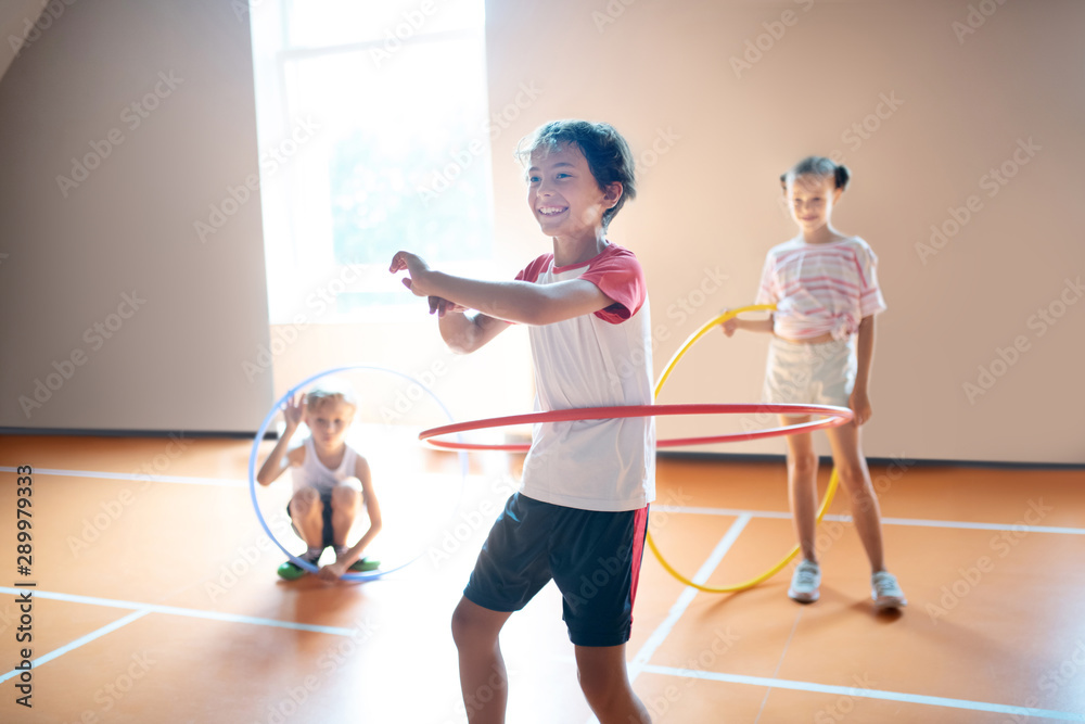 Boy laughing while rolling hula-hoop for the first time Stock Photo ...