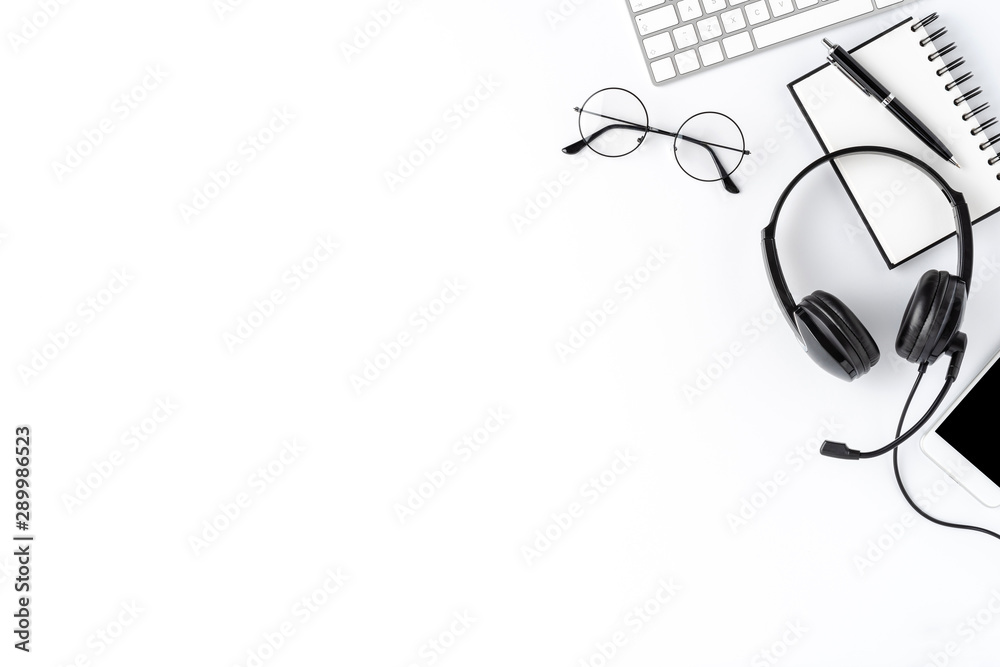 Call center desktop with headset and accessories on white table. Top ...