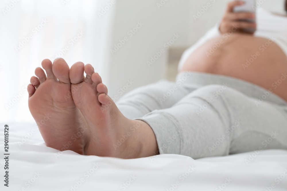 Pregnant women with swelling feet, pain foot and lying on bed in the ...