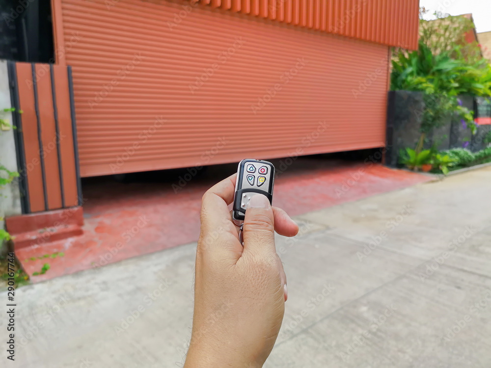 Hand holding the remote to open the sliding door.Remote control door ...