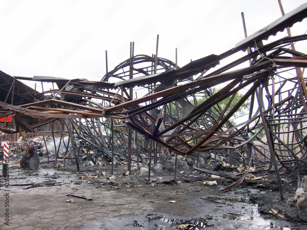 Twisted steel beams after a factory fire. Warehouse destroyed by fire ...