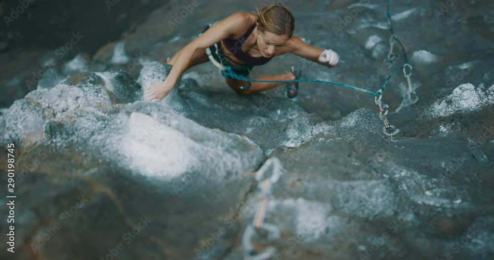 Young fit woman rock climbing outdoors on sport route, cinematic slow ...