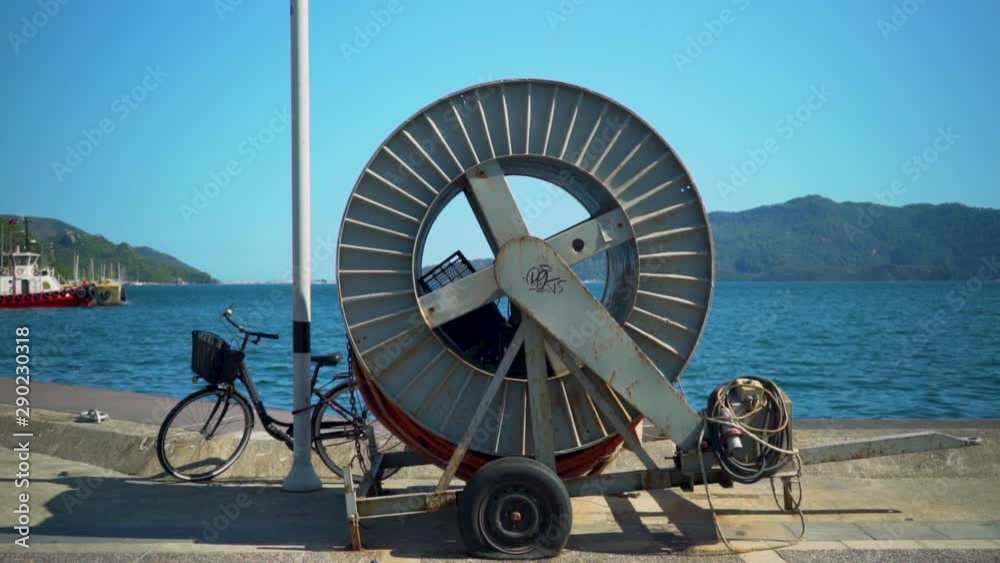 This shot depicts a view of giant rope/cable reel with a backdrop to ...