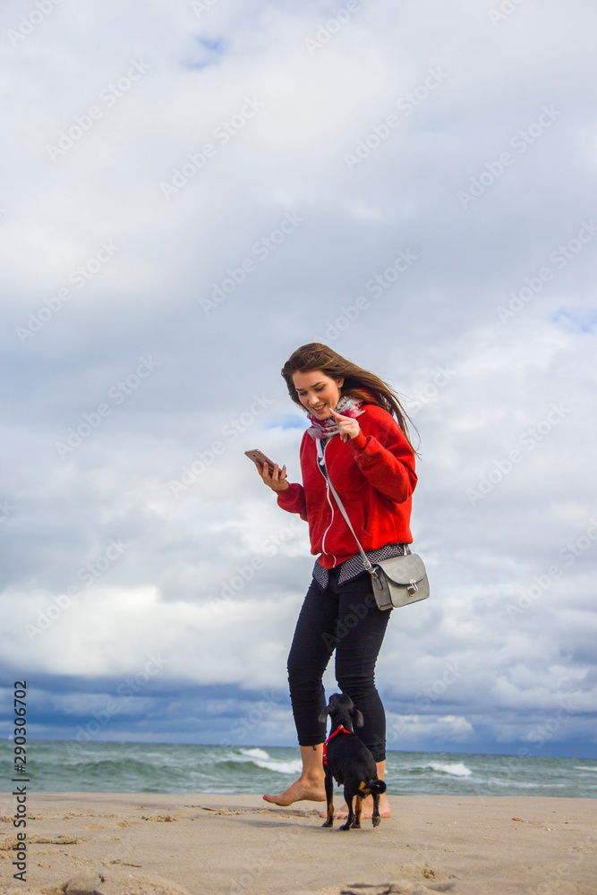 Foto de Piesek pinczer miniaturowy ratlerek bawi się z młodą dziewczyną ...