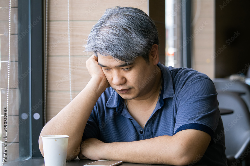 Stressed tired young Asian middle-aged man,old man take hand on head ...