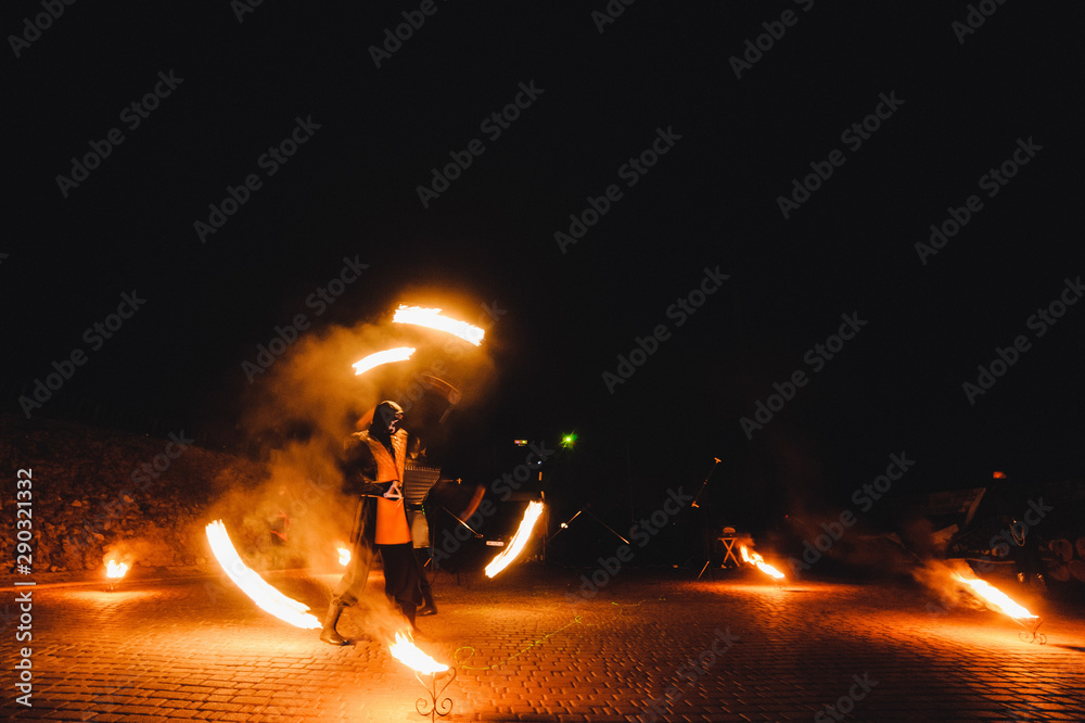 A man in a suit LED dances with fire night..fire show at a wedding and ...