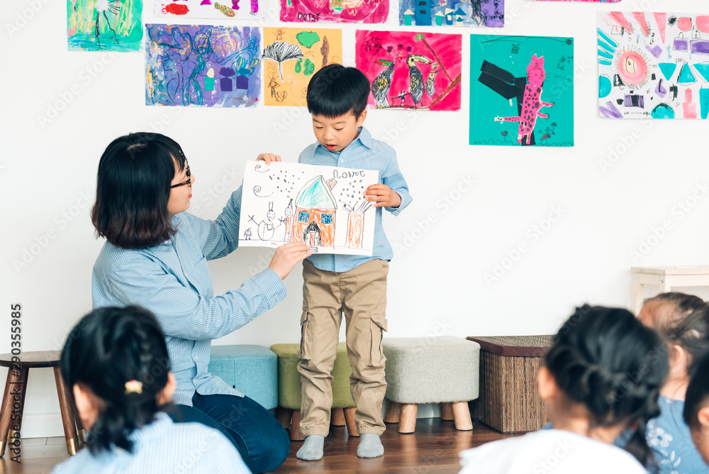 Preshool kid showing drawing to class Stock Photo | Adobe Stock
