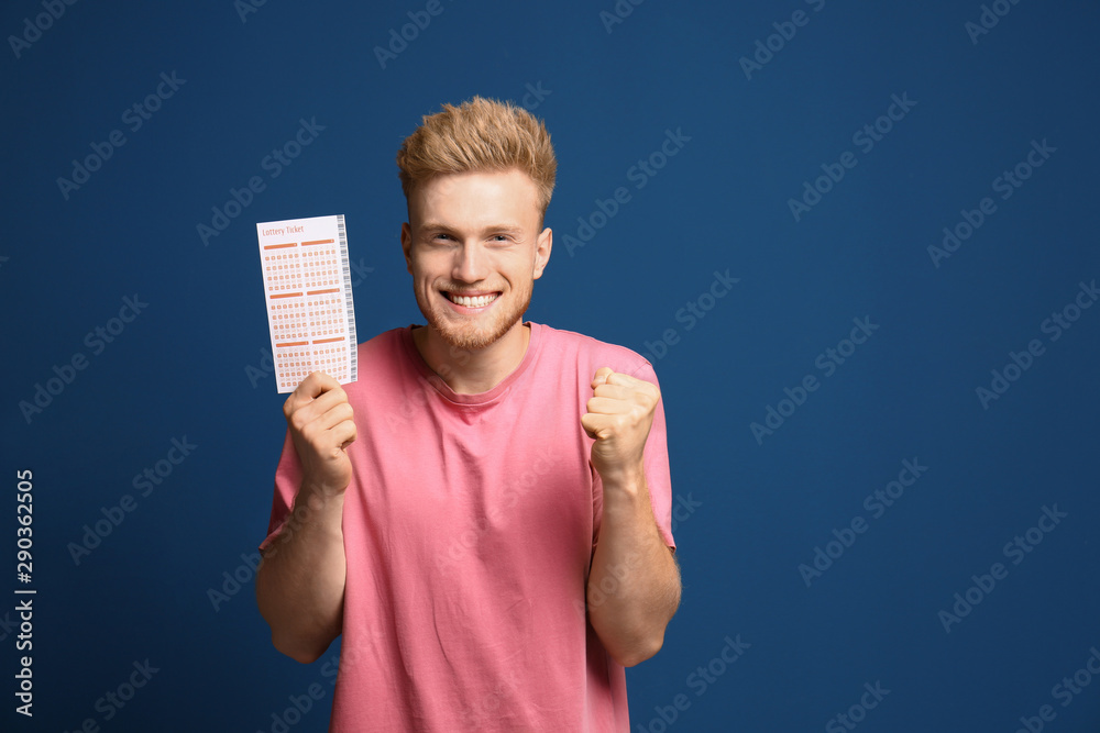 Foto de Portrait of happy young man with lottery ticket on blue ...