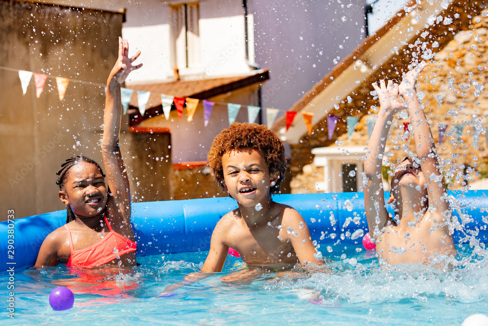 Three happy kids splash in small swimming pool Stock Photo | Adobe Stock