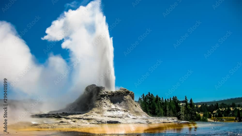 Castle Geyser erupts with hot water and steam with pools of ...