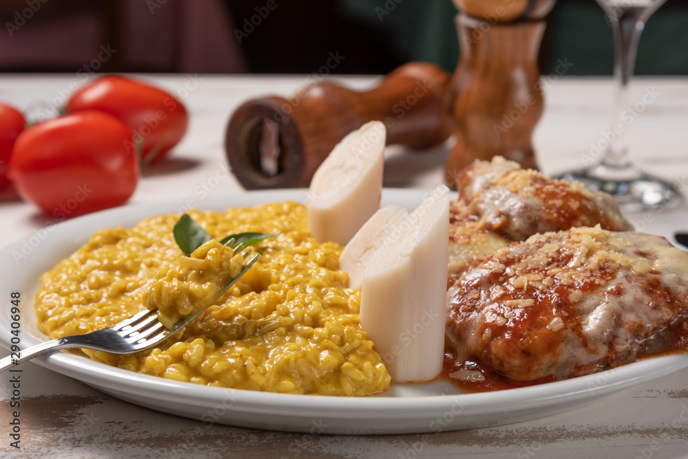 Saffron Risotto with parmigiana steak beef. Risoto and beef in a white ...