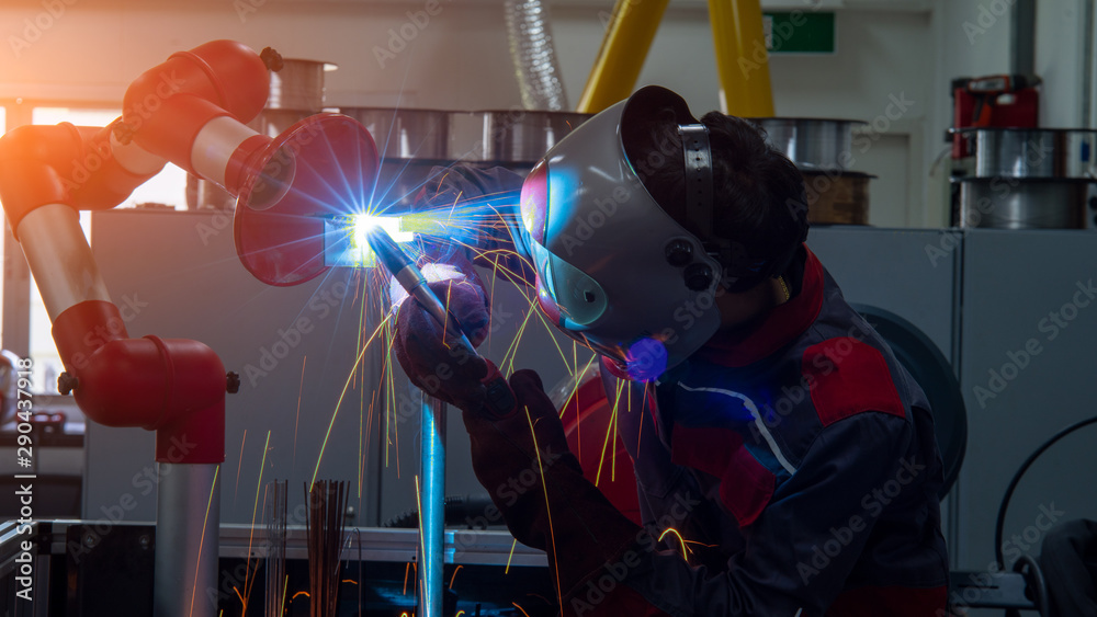 Welder is welding metal part in on smart factory, industry 4.0 in ...