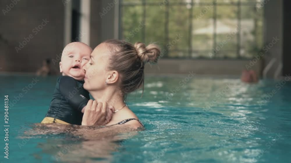 Mother and baby swim in the pool. Baby swimming in a pool with her ...