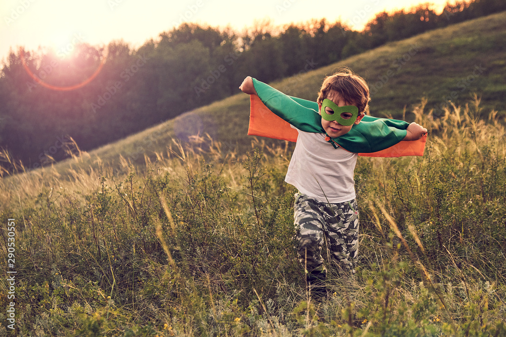 little boy playing a superhero. Kid in an Superhero's costume. happy ...