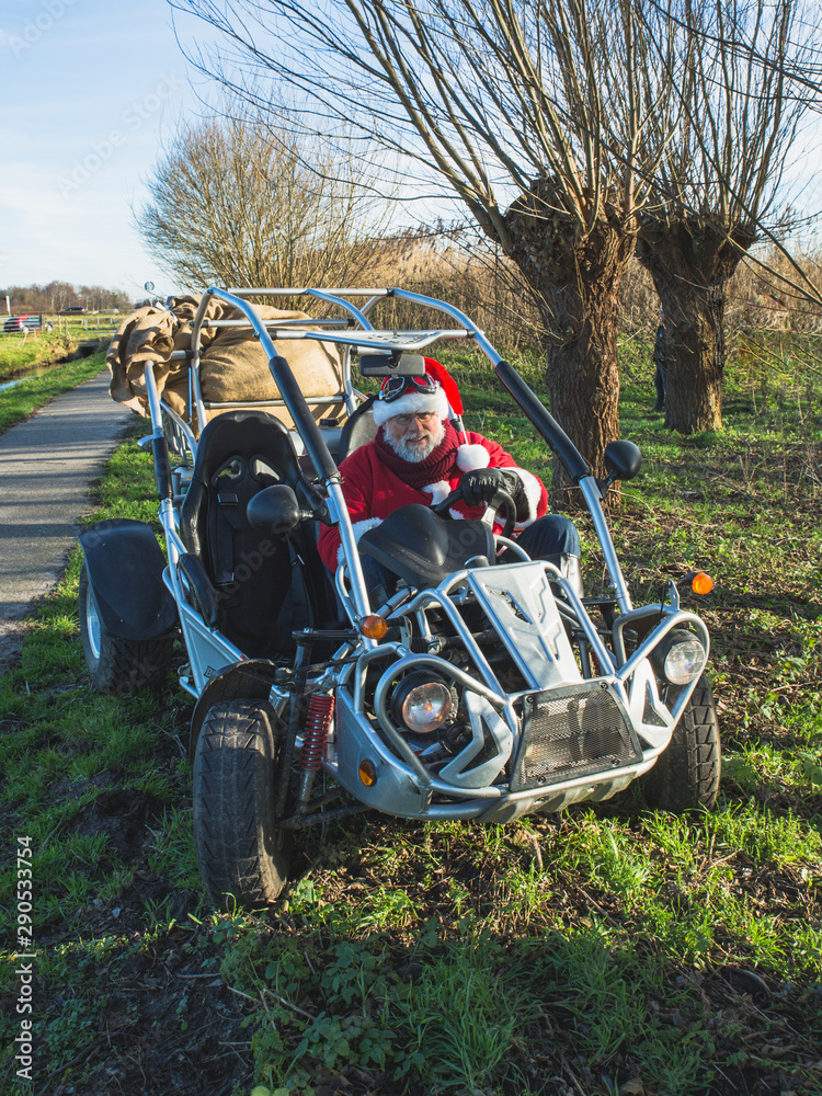 Santa Claus in leather gloves sits in a buggy car with a big sack of ...