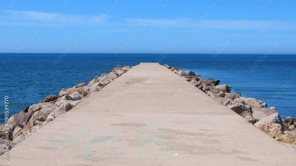 Seascape background with empty long stone concrete pier stretching out ...