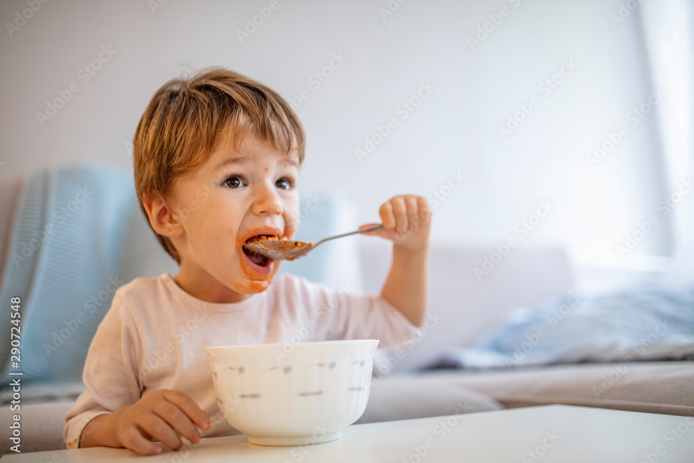 Cute child eating healthy food with with the left hand at home. Cute ...