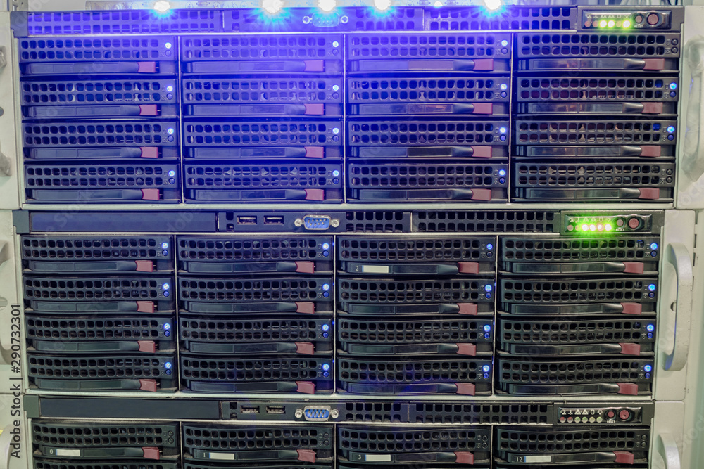 Servers with many hard drives are in data center. There is a lot of ...