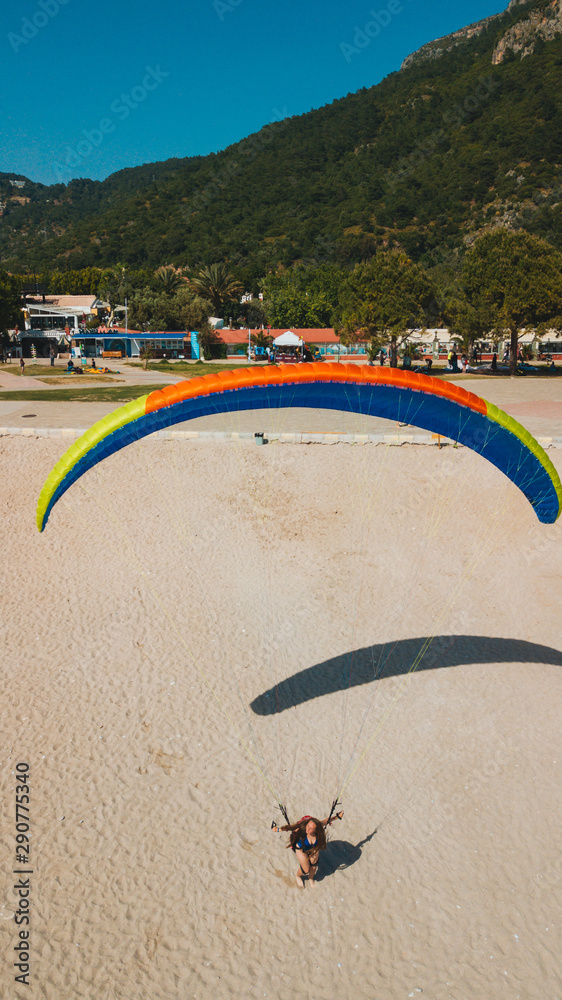 Ground handling on the beach. Young girl paraglider pilot exercises ...
