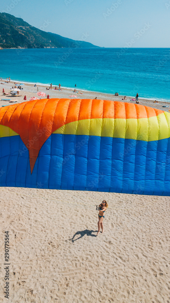 Ground handling on the beach. Young girl paraglider pilot exercises ...
