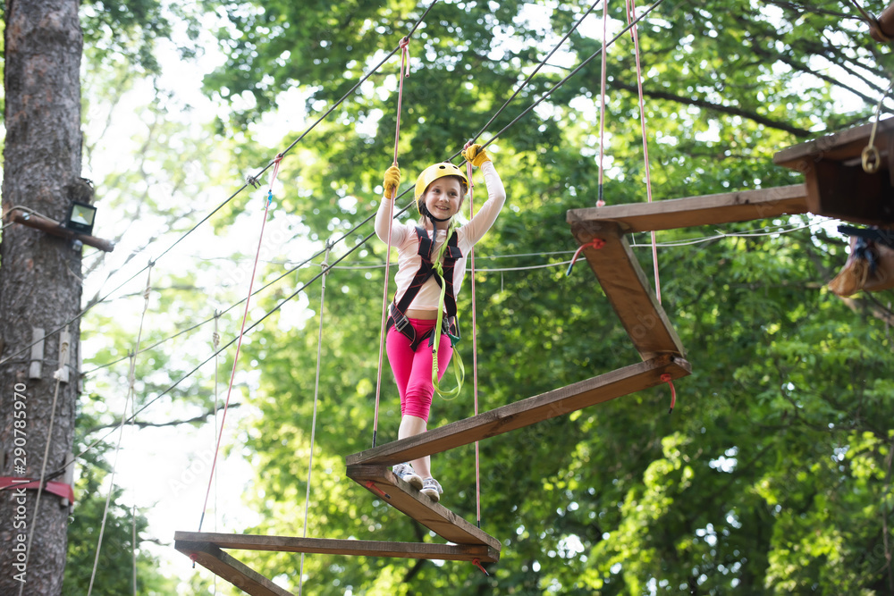 Every childhood matters. High ropes walk. Little girl climbing in ...