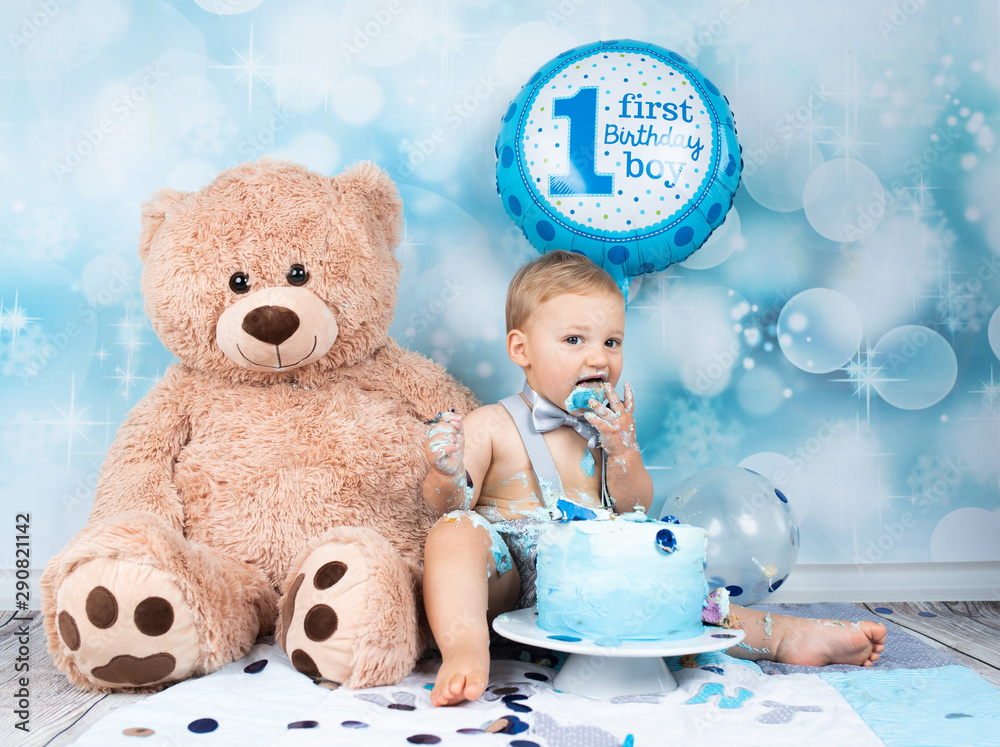 First Birthday Boy. One year old toddler posing for a messy cake smash ...