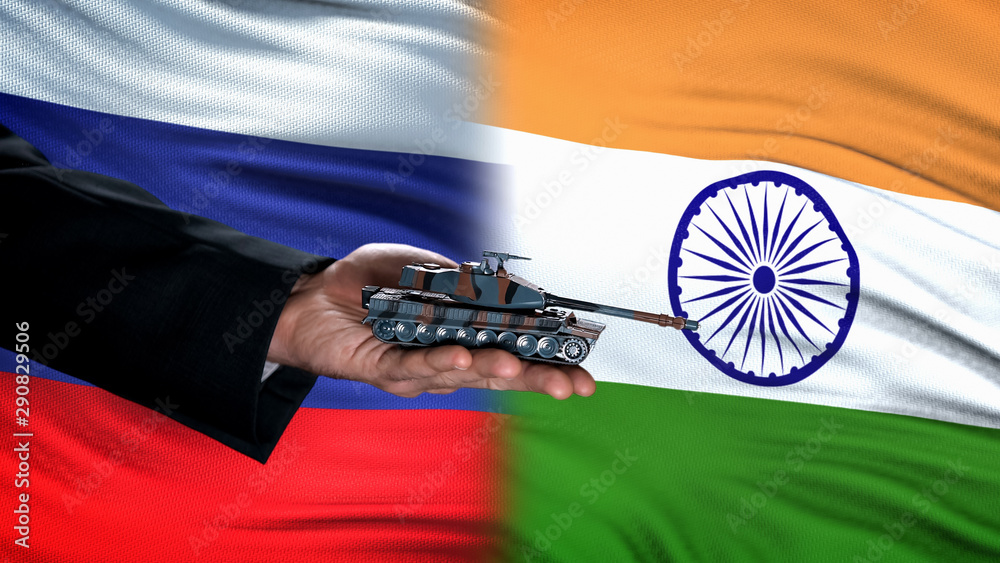 Official hand holding toy tank against Russia and India flag, weapon ...