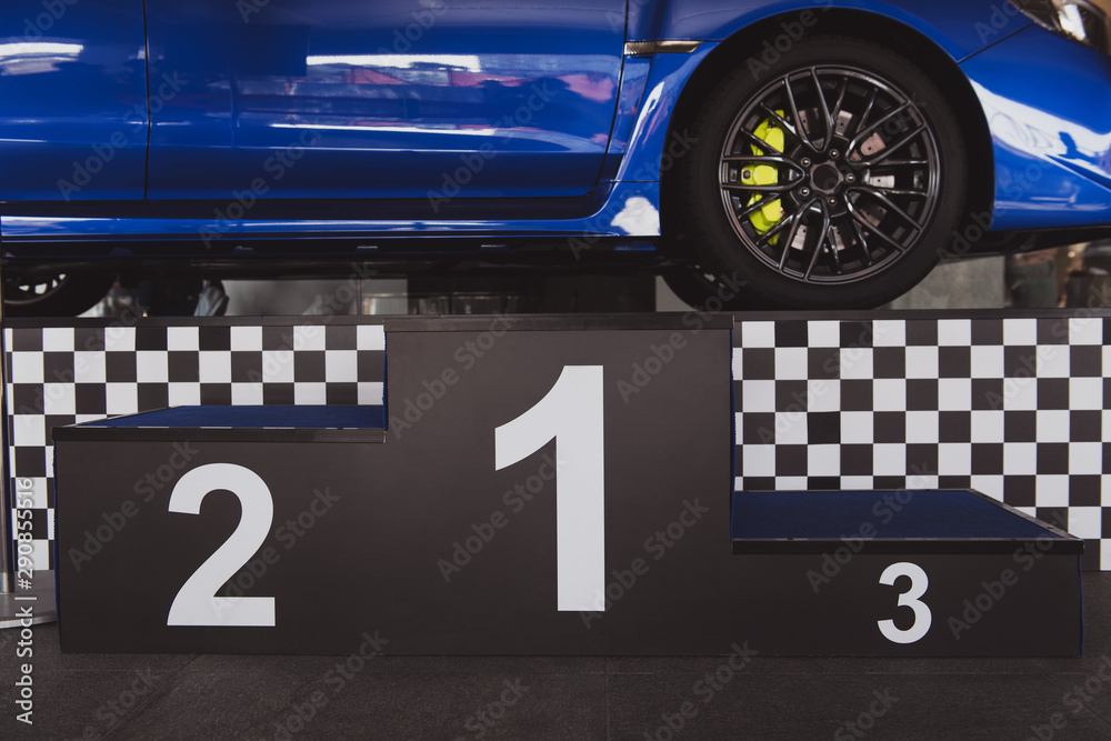 Powerful blue sports car behind the pedestal. Rally pedestal with first ...