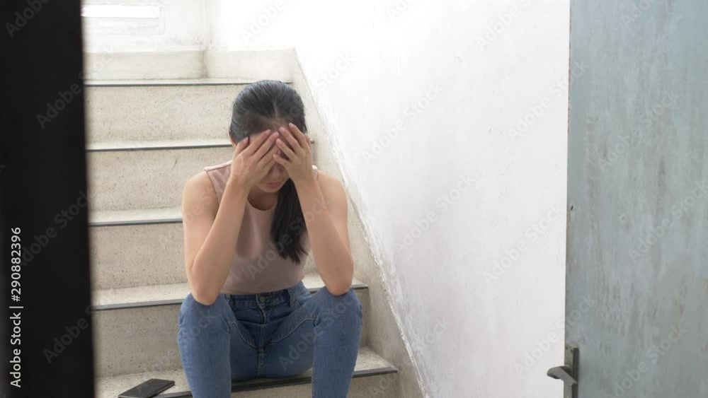 sad young girl reading cyber bullying phone message with face in hands ...