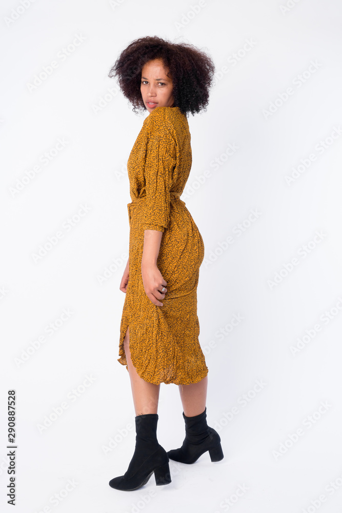 Full body shot of young beautiful African woman looking over shoulder ...