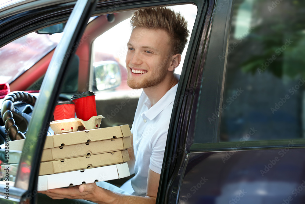 Worker of food delivery service in car Stock Photo | Adobe Stock