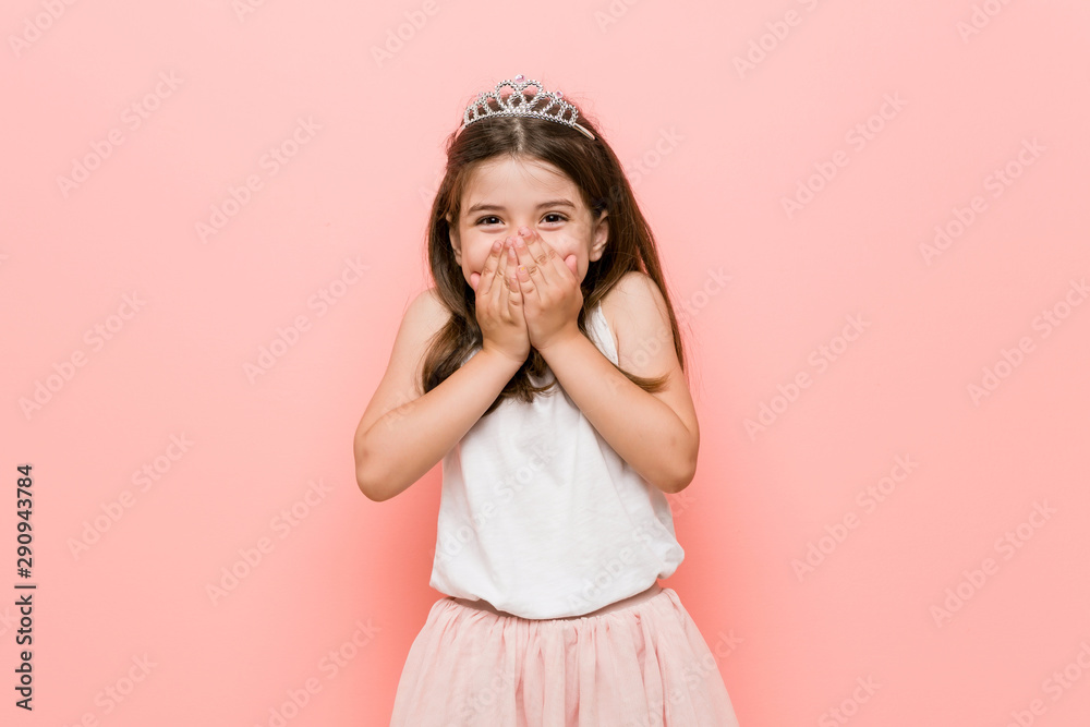 Little girl wearing a princess look laughing about something, covering ...